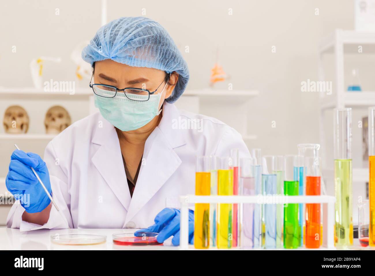 An Asian female scientist is researching a chemical formula in a lab ...
