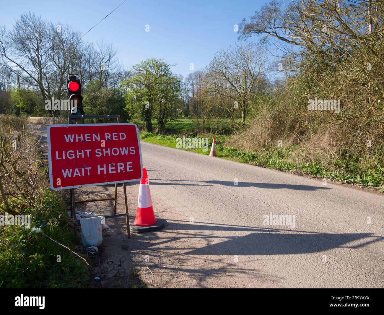 Temporary traffic lights in a country lane due to roadworks Stock Photo ...