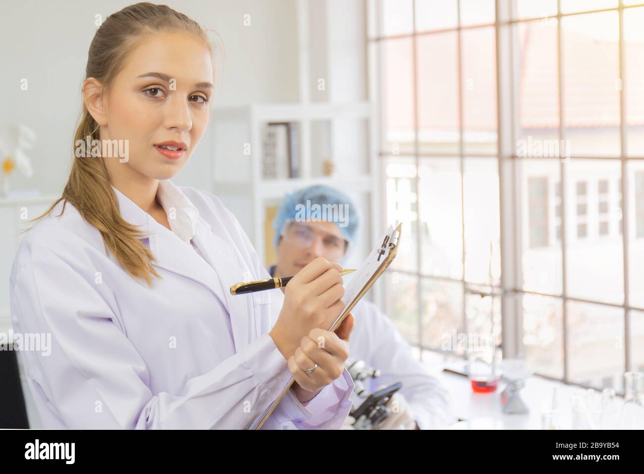 Male and female scientists working in a science laboratory with various ...