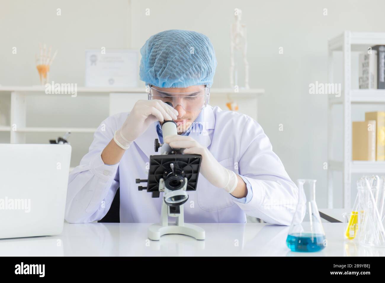 Young Scientist using Microscope in Laboratory. Male Researcher wearing ...