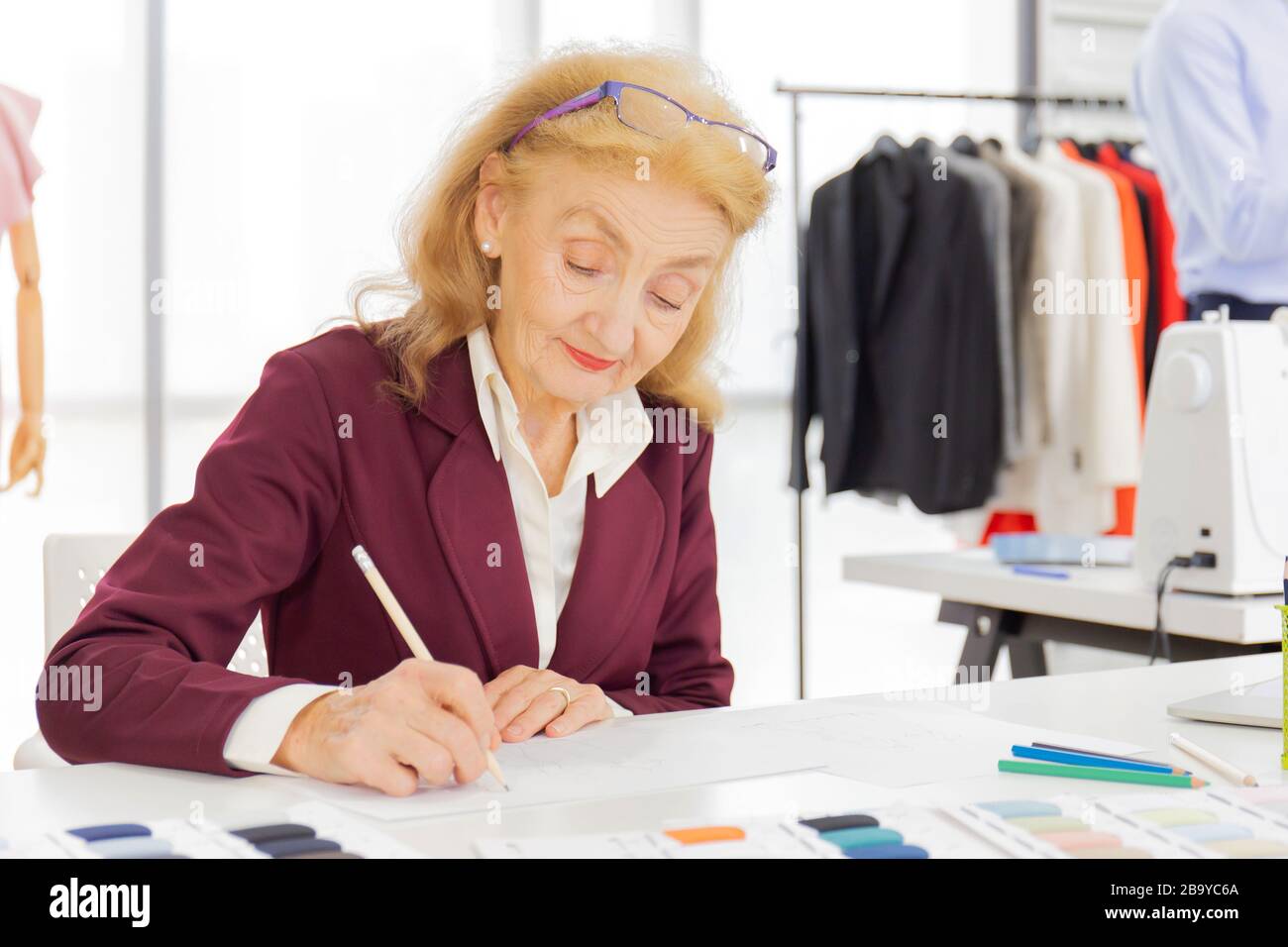 Professional female designers are drawing sketches on paper with ...