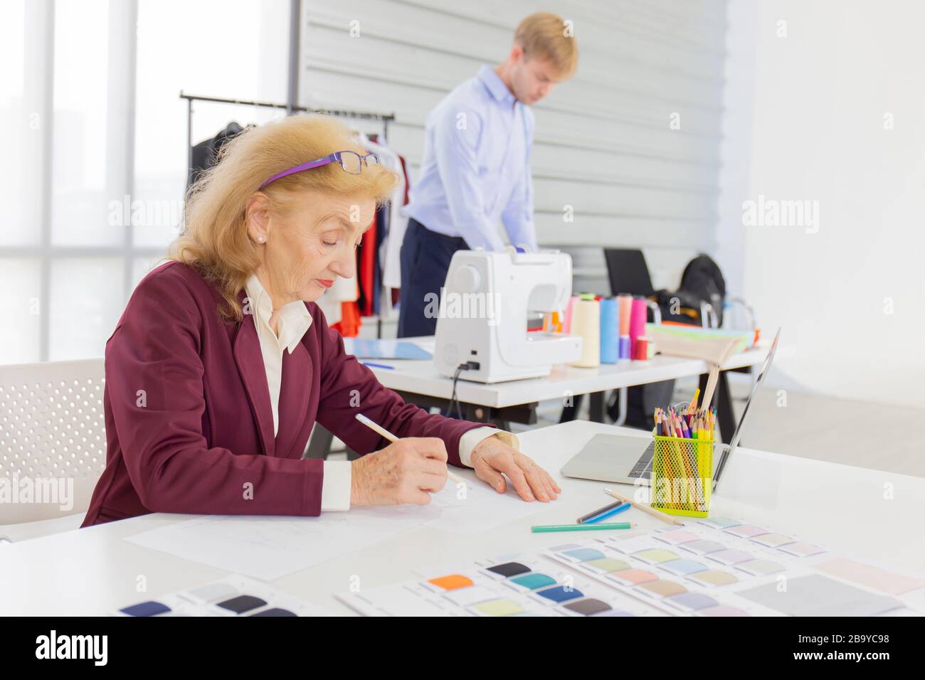 Professional female designers are drawing sketches on paper with ...