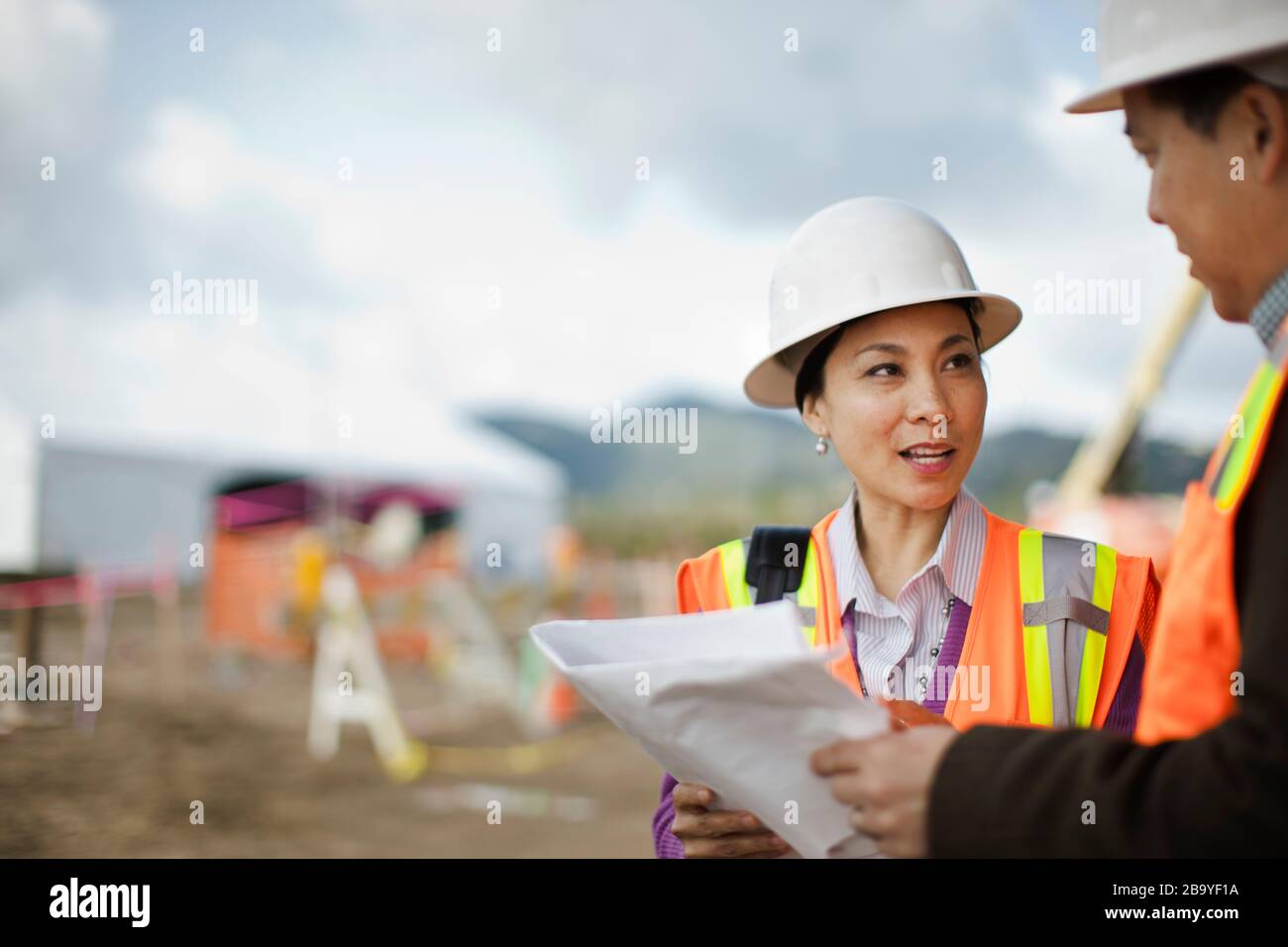 Two colleagues discussing a project on a construction site Stock Photo ...