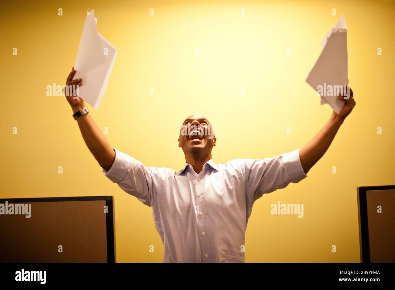Man shouts throwing paper into the air arms raised Stock Photo - Alamy
