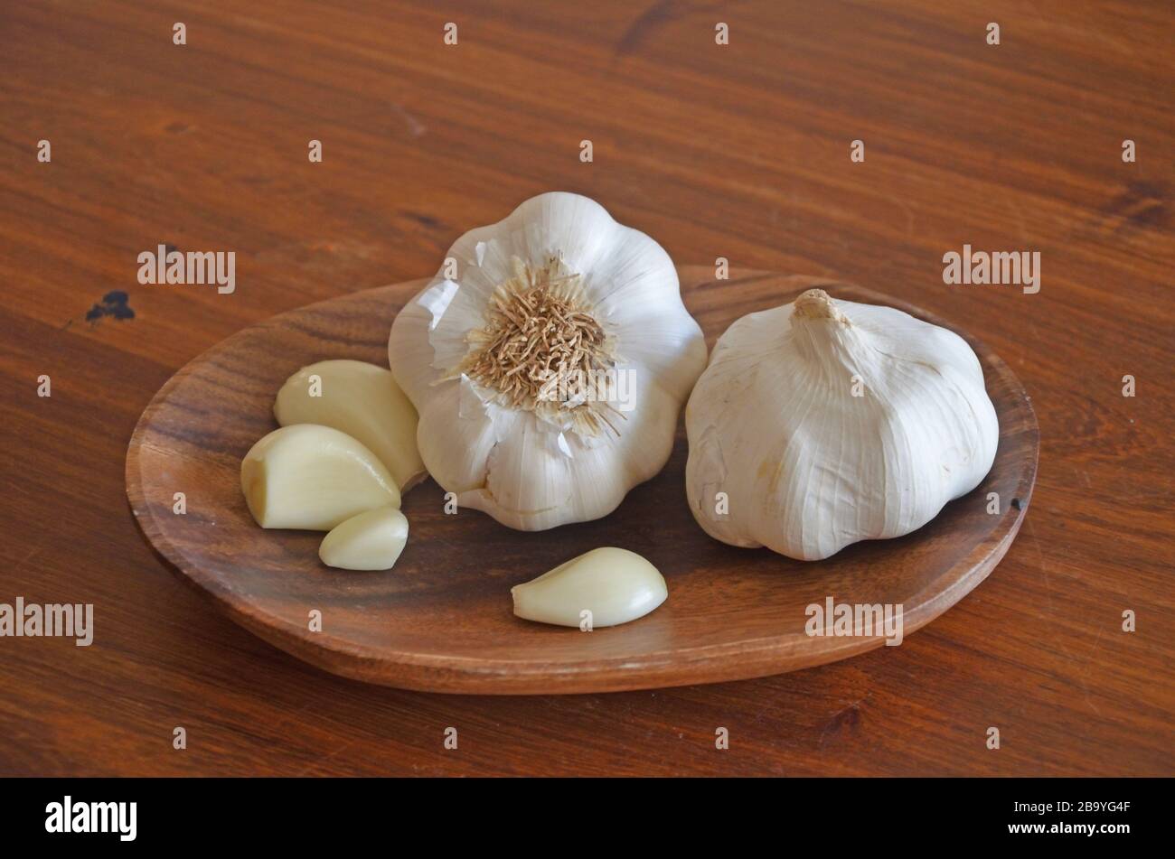 Fresh whole garlic and garlic cloves in wooden bowl Stock Photo - Alamy