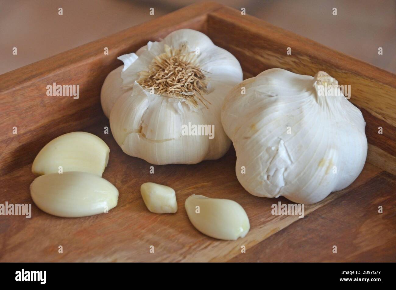 Fresh whole garlic and garlic cloves in wooden bowl Stock Photo - Alamy