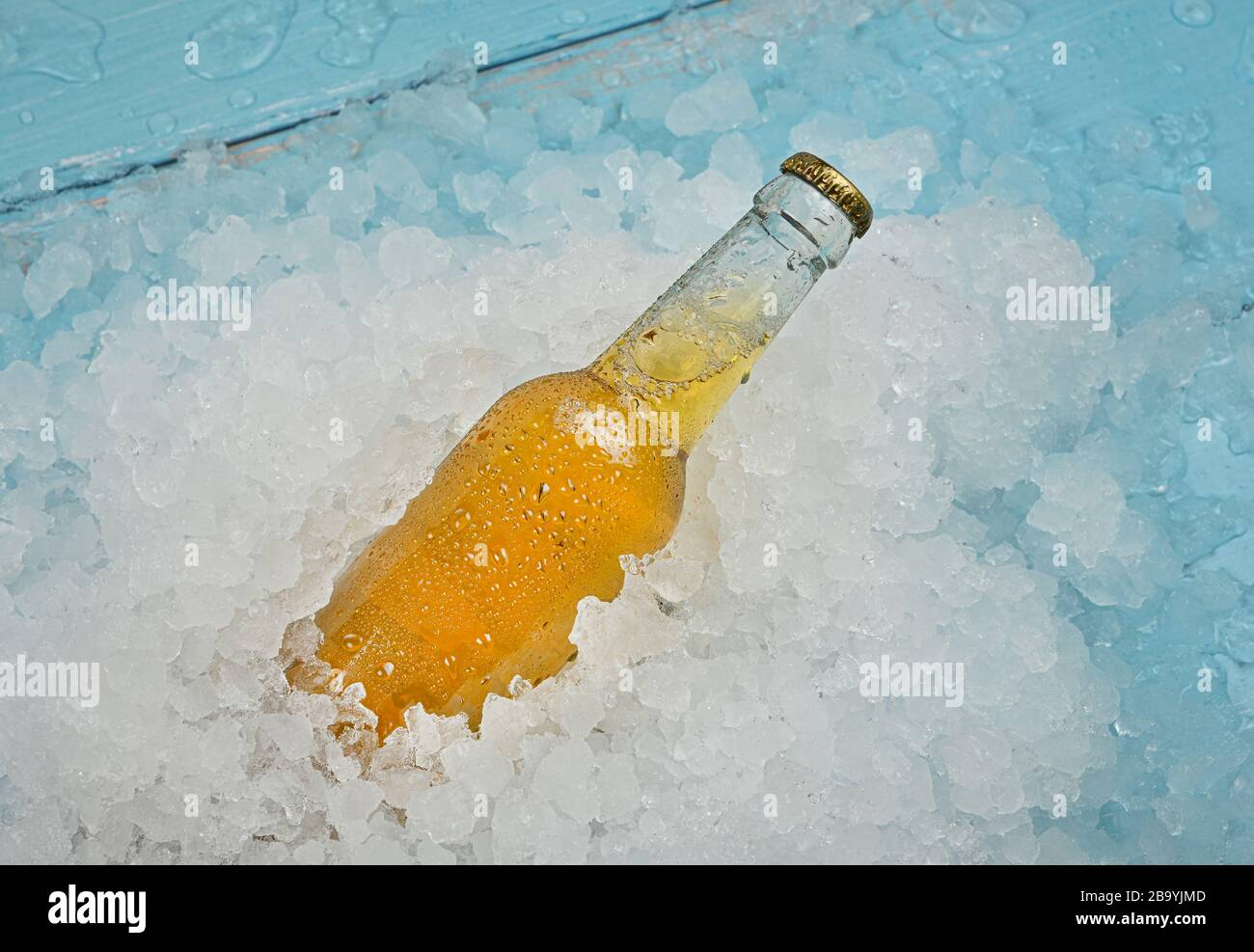 Close up one clear glass bottle of cold lager beer on crushed ice at ...