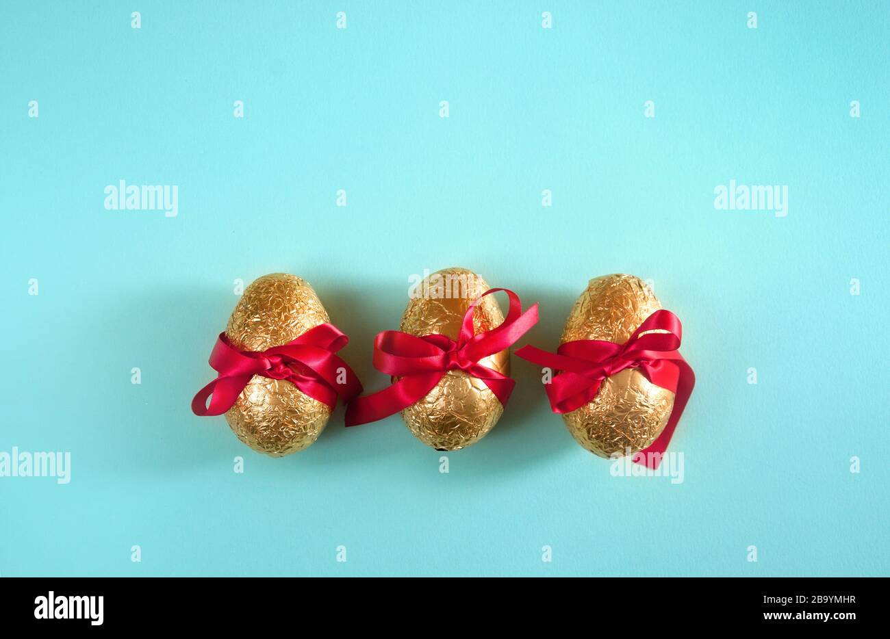 Three chocolate easter eggs tied with red silk ribbon Stock Photo - Alamy