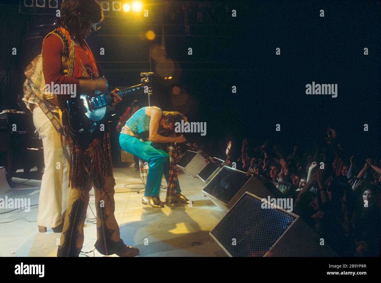 Rod Stewart having his scarf pulled by audience members playing with ...