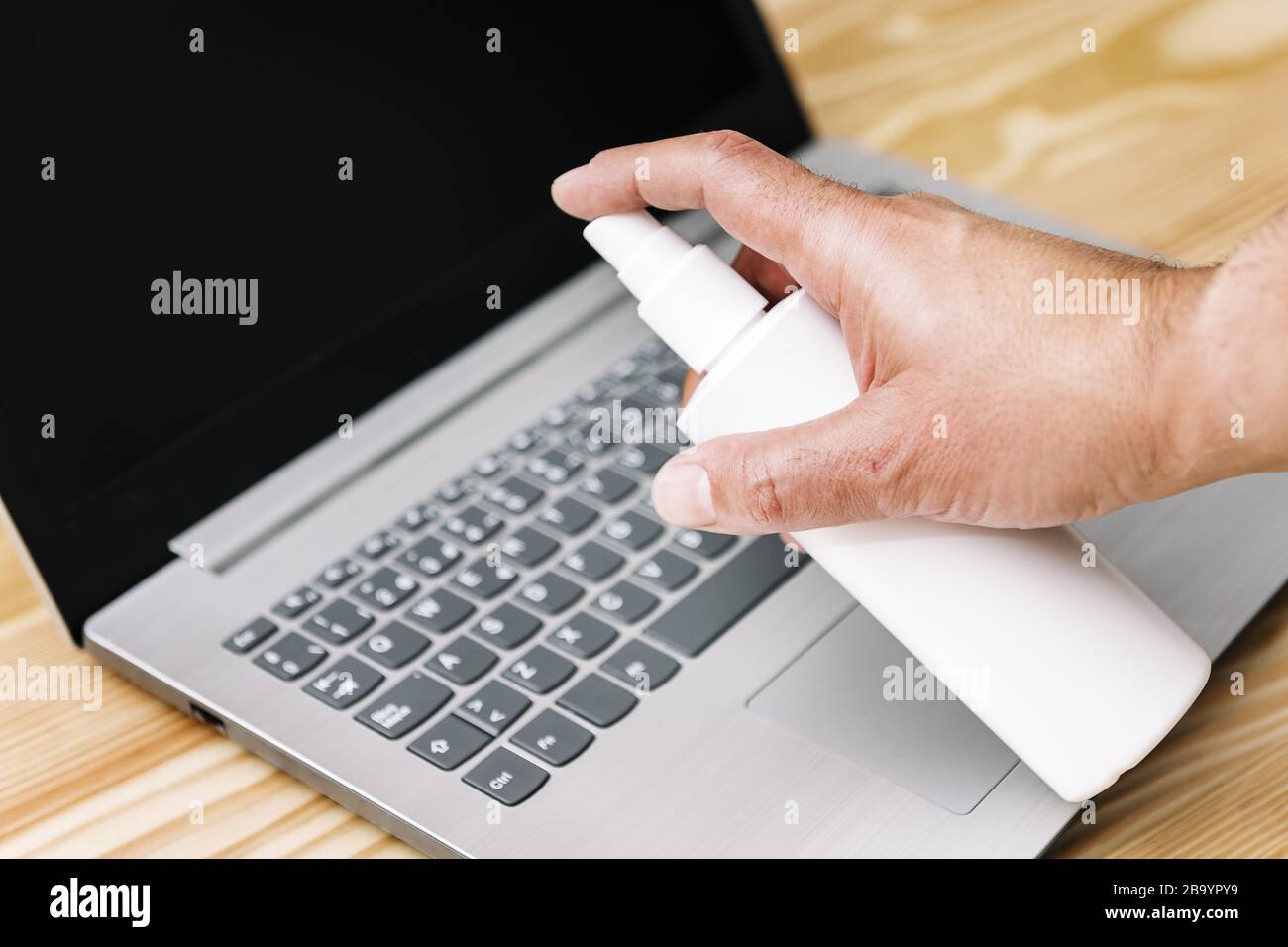 hand sanitizing computer with antibacterial spray, hygiene concept and ...