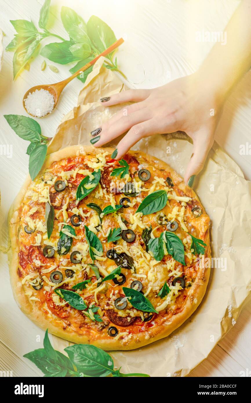 Hand taking pizza slices from white wooden background. Pizza and hand ...