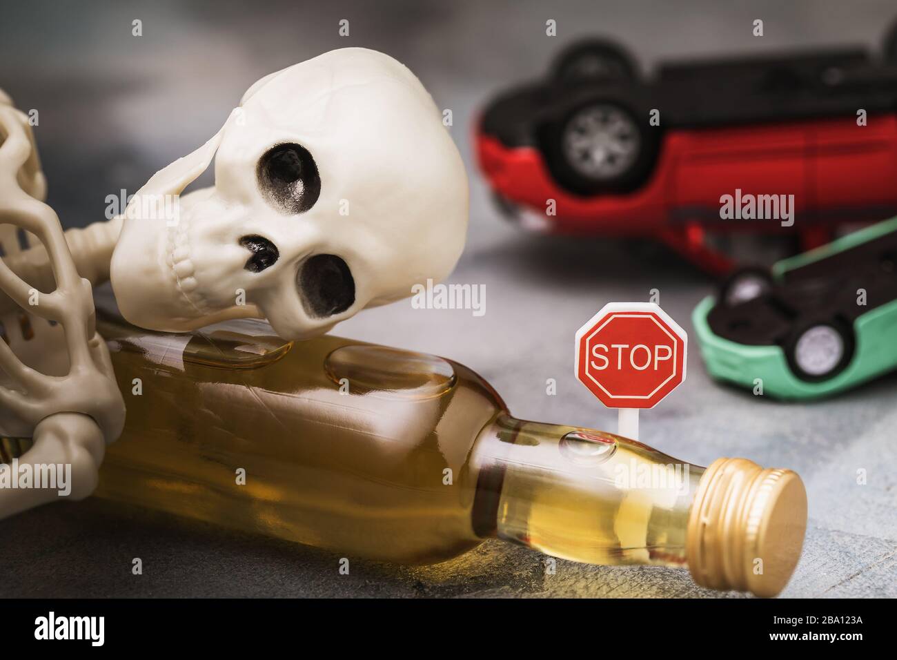 Road sign, a bottle of whiskey, a skeleton and an inverted car. Concept ...