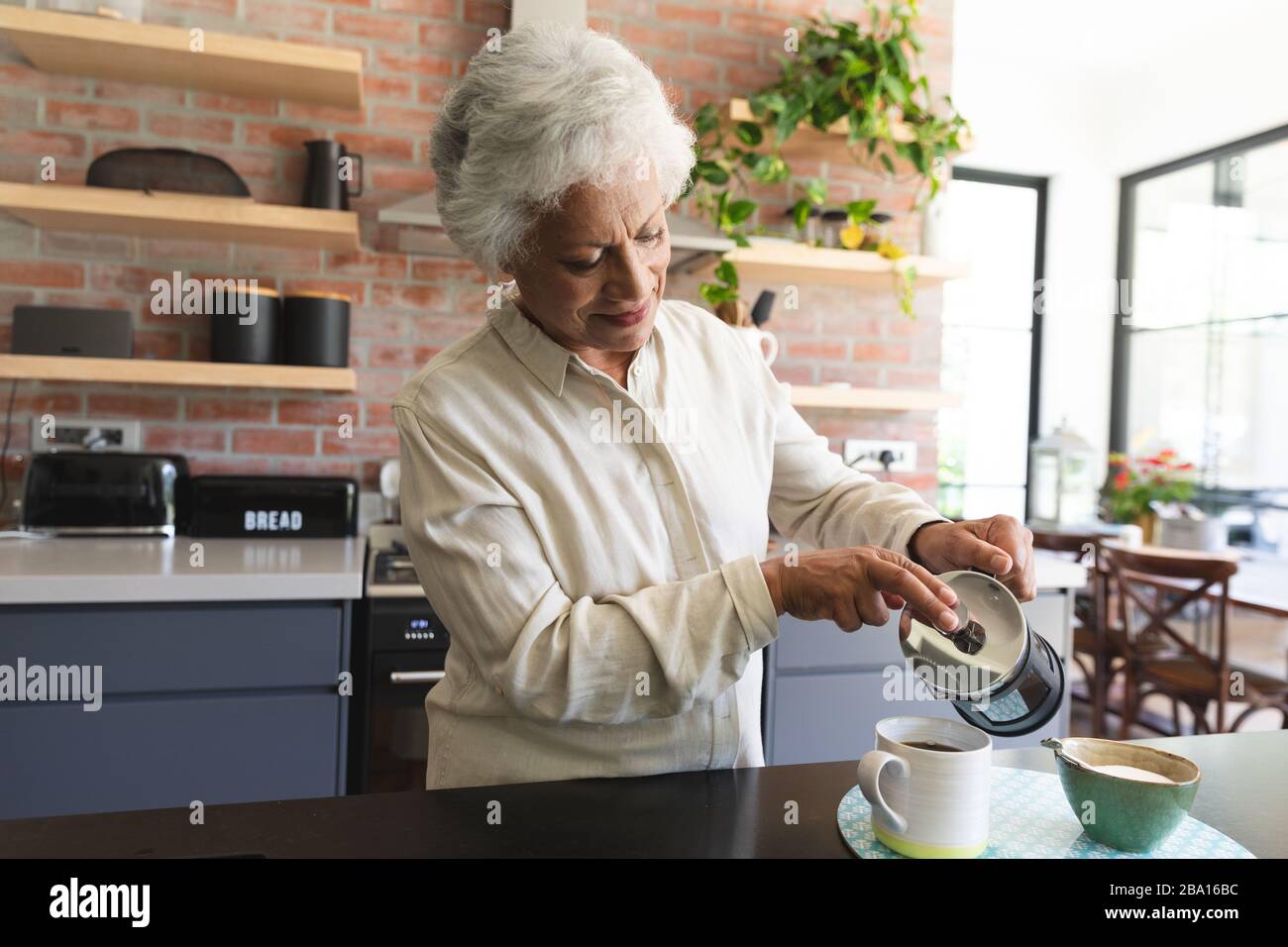 Woman in kitchen pouring tea hi-res stock photography and images - Alamy