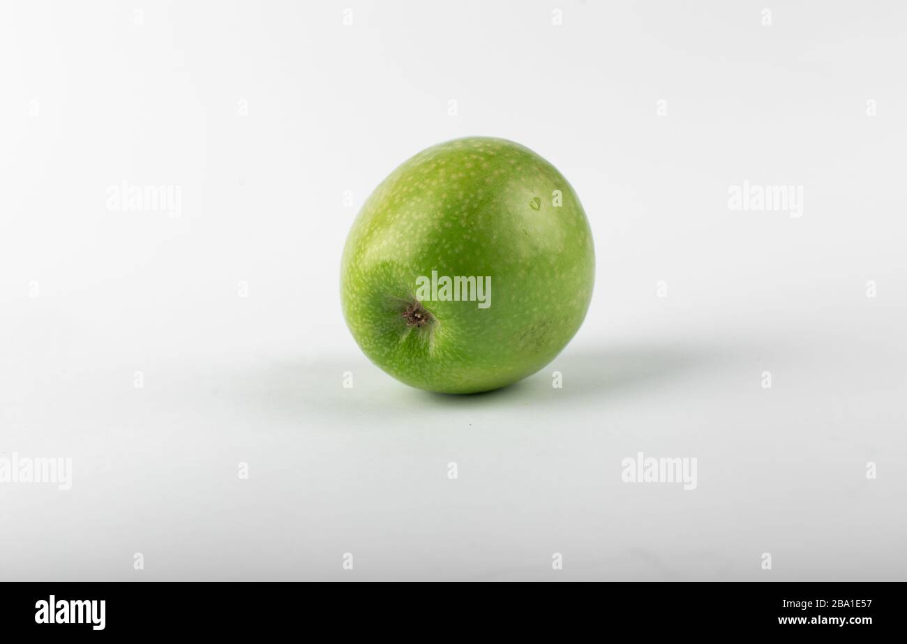 A single green fresh apple isolated on white background. shining lights ...