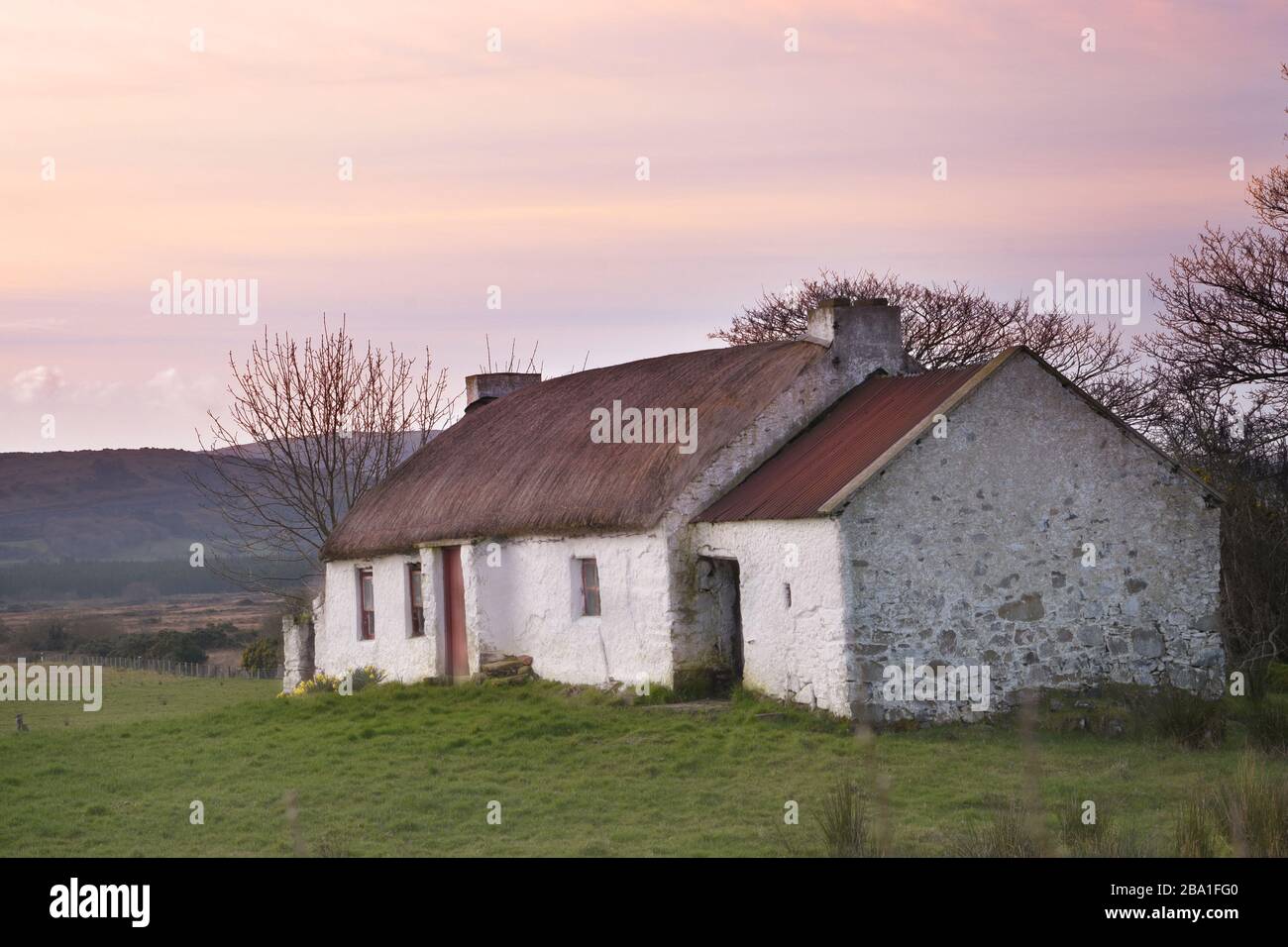 Traditional thatched stone cottage in rural Ireland captured in sunrise ...