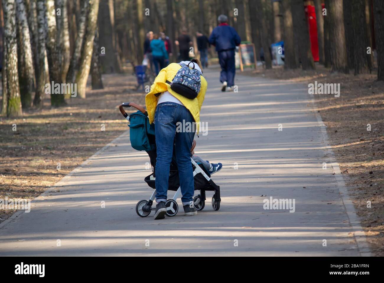 Mom with stroller for a walk in the park. People Stock Photo - Alamy
