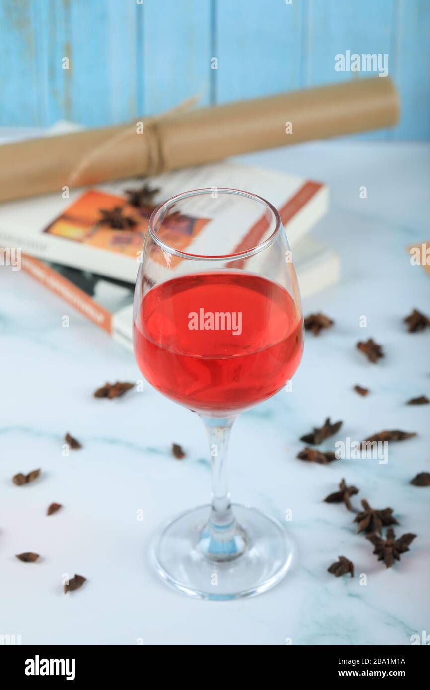 A glass of red rose wine with anise flowers around Stock Photo - Alamy