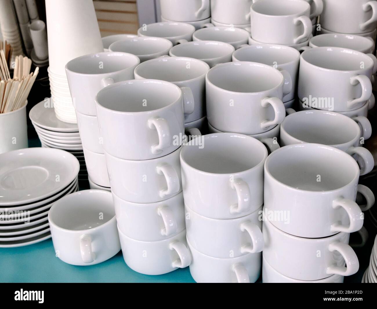 Exposed on stacks of white clean ceramic cups and saucers. The dishes ...