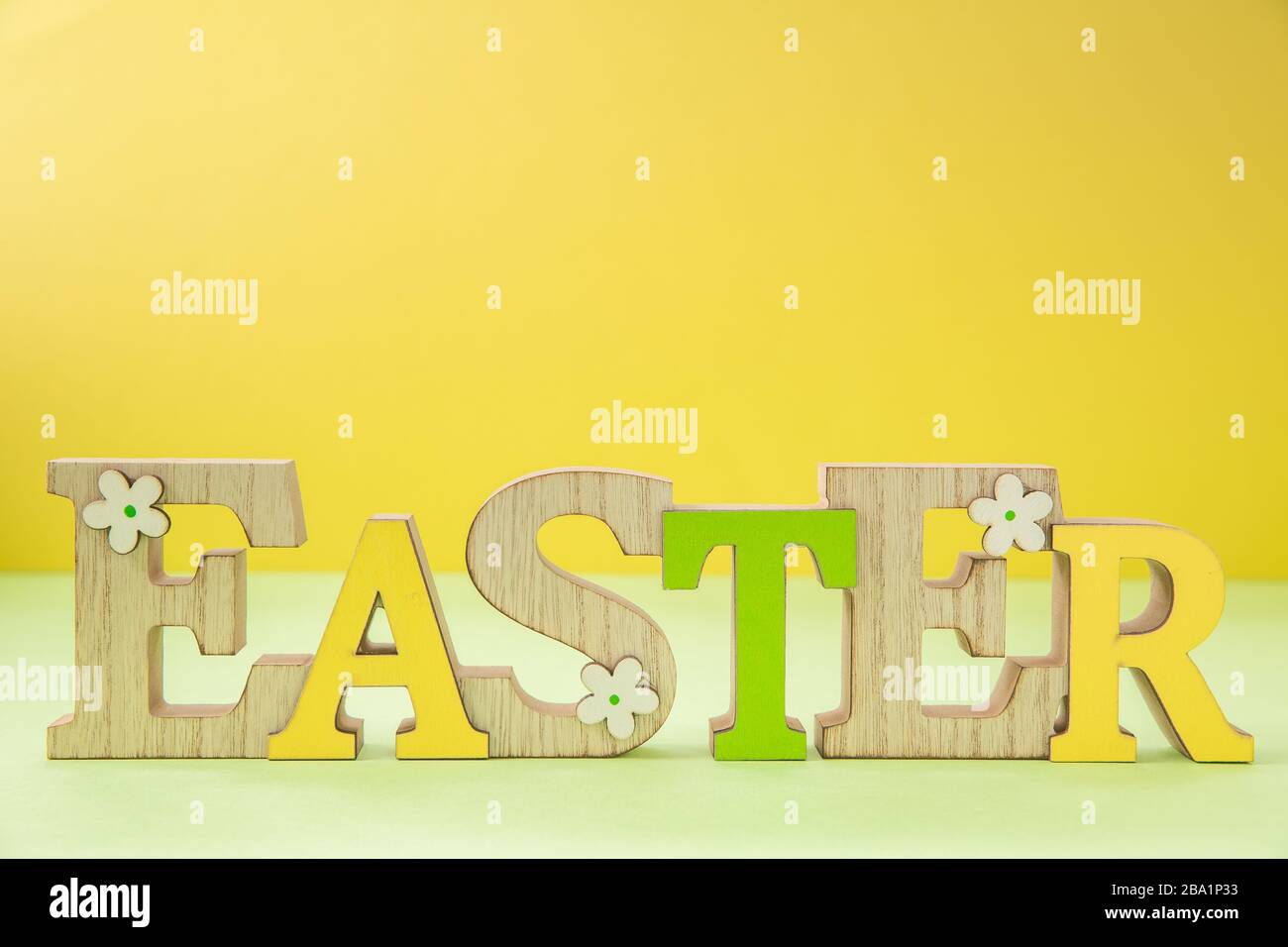 A colourful easter sign with seasonal flowers on a yellow background ...