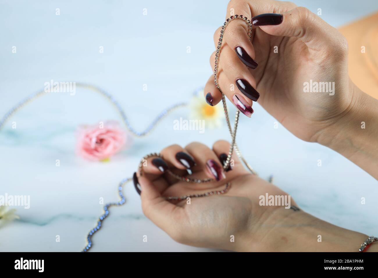 Well manicured woman hands holding a necklace Stock Photo - Alamy