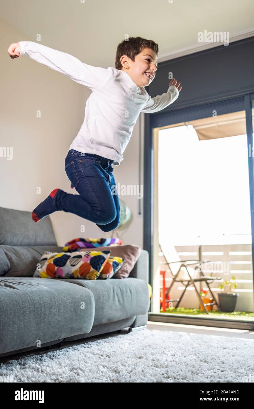 Funny kid jumping off the couch Stock Photo - Alamy