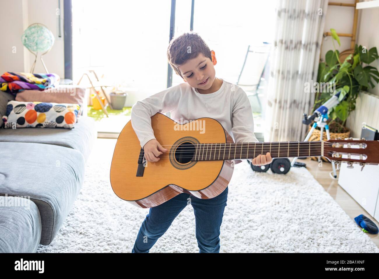 Funny kid playing guitar Stock Photo - Alamy