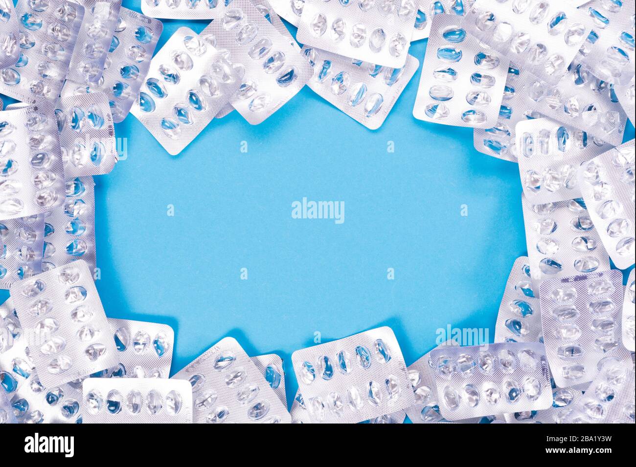 Empty silver packaging for medicines, pills on a blue background with a ...