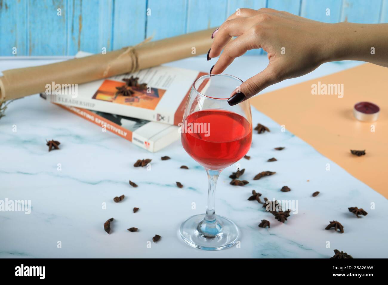 Red rose wine in a glass taken by hand of a woman Stock Photo - Alamy