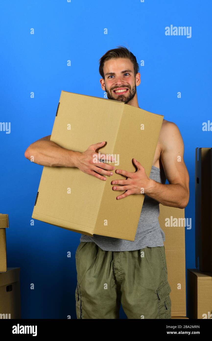 Guy hugging carton isolated on blue background. Macho with beard and ...