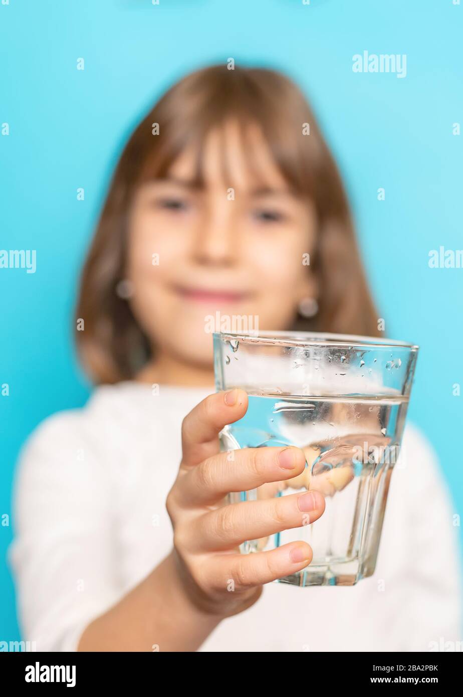Child girl drinks water from a glass. Selective focus Stock Photo - Alamy