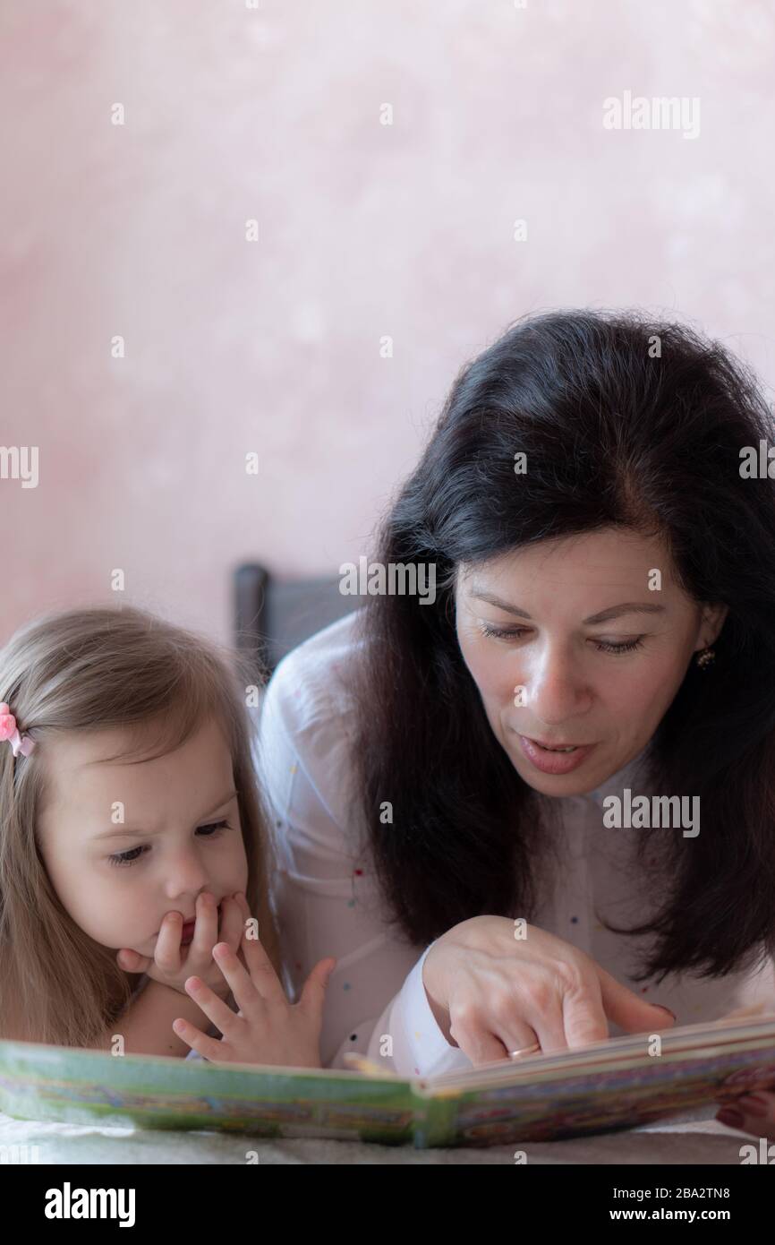 Grandmother with grandson and granddaughter in bed reading a book ...