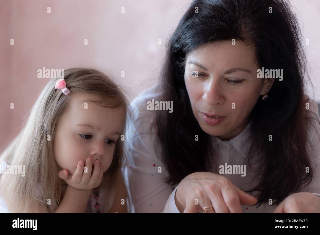 Grandmother with grandson and granddaughter in bed reading a book ...