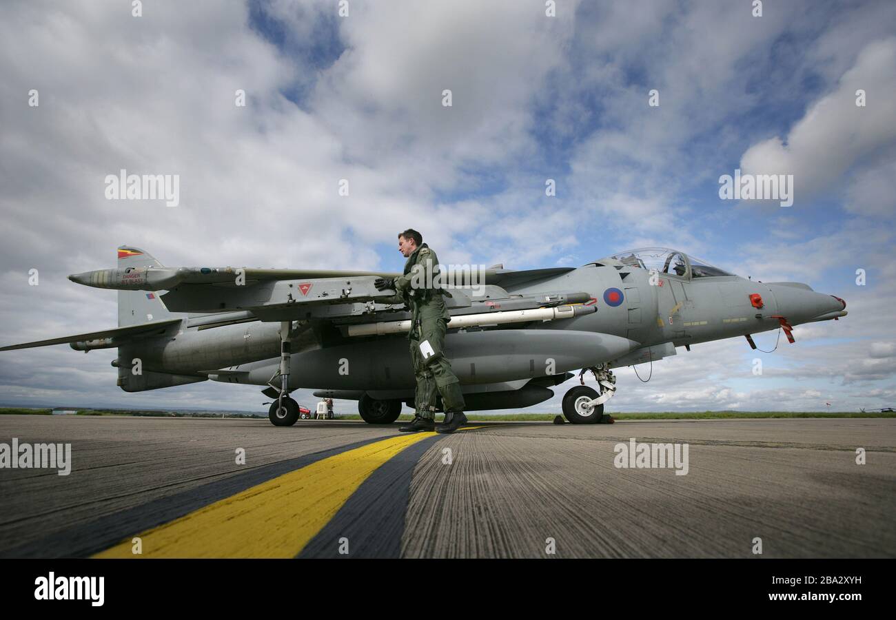 Flight Lieutenant Andy Chisholm, checks over his Harrier before the ...