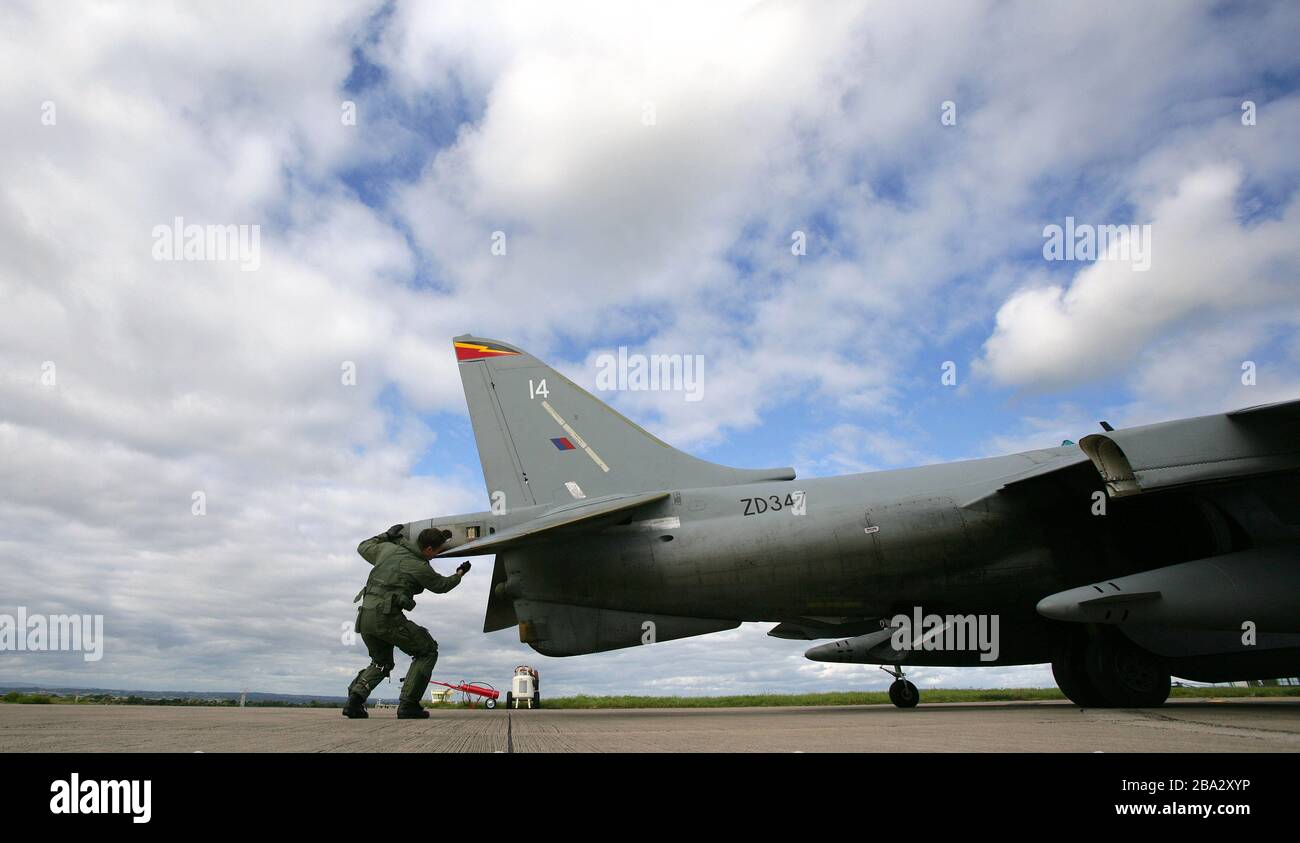 Flight Lieutenant Andy Chisholm, checks over his RAF Harrier before the ...