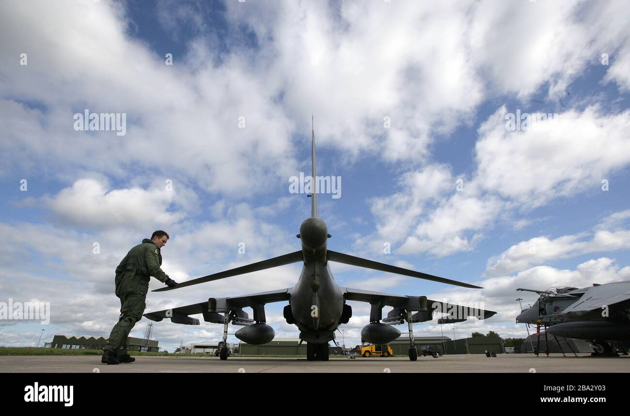 Flight Lieutenant Andy Chisholm, checks over his RAF Harrier before the ...
