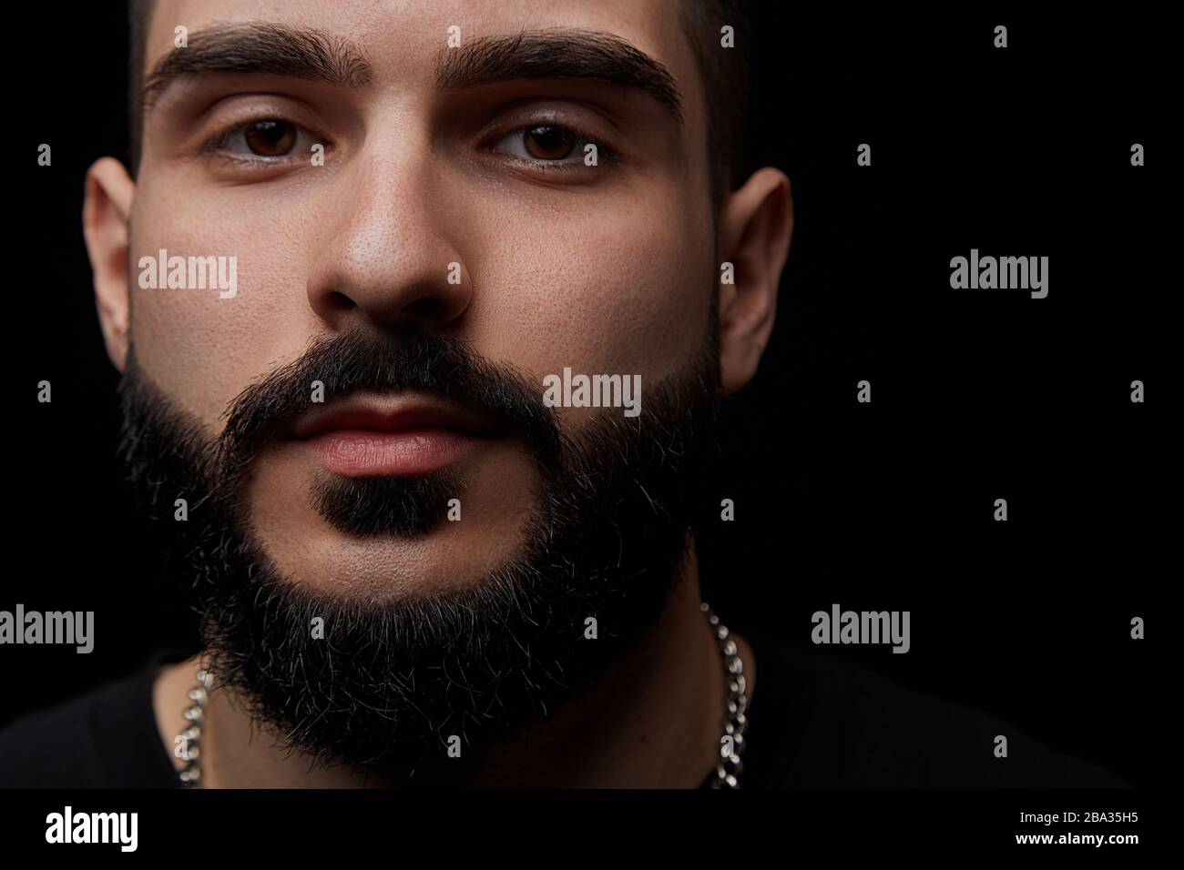 a close-up dramatic portrait of a young serious guy, musician, singer ...