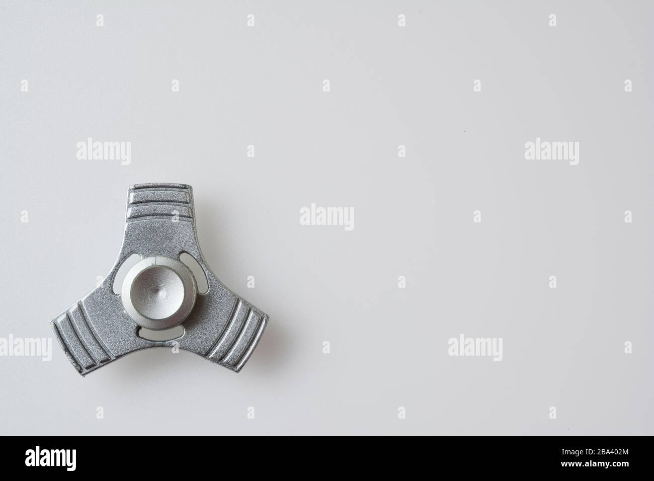 Silver fidget spinner over white background, lot of copy space on right ...