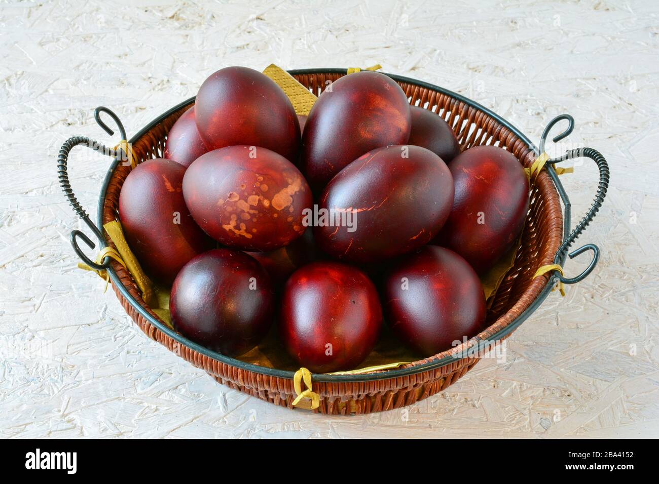 Lot of Easter eggs naturaly painted by onion shells in a wicker basket ...