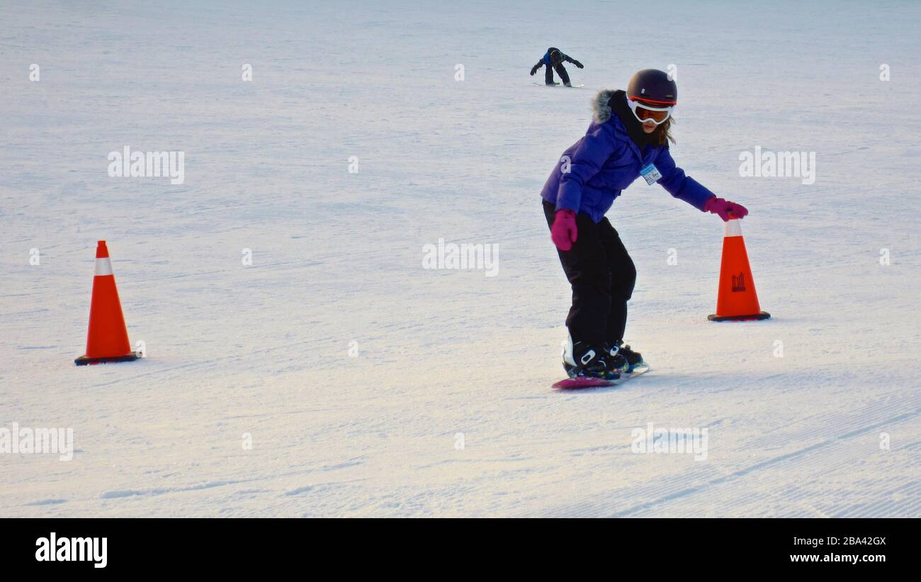 Winter sport - young girl learning to play skyboard in winter, outside ...