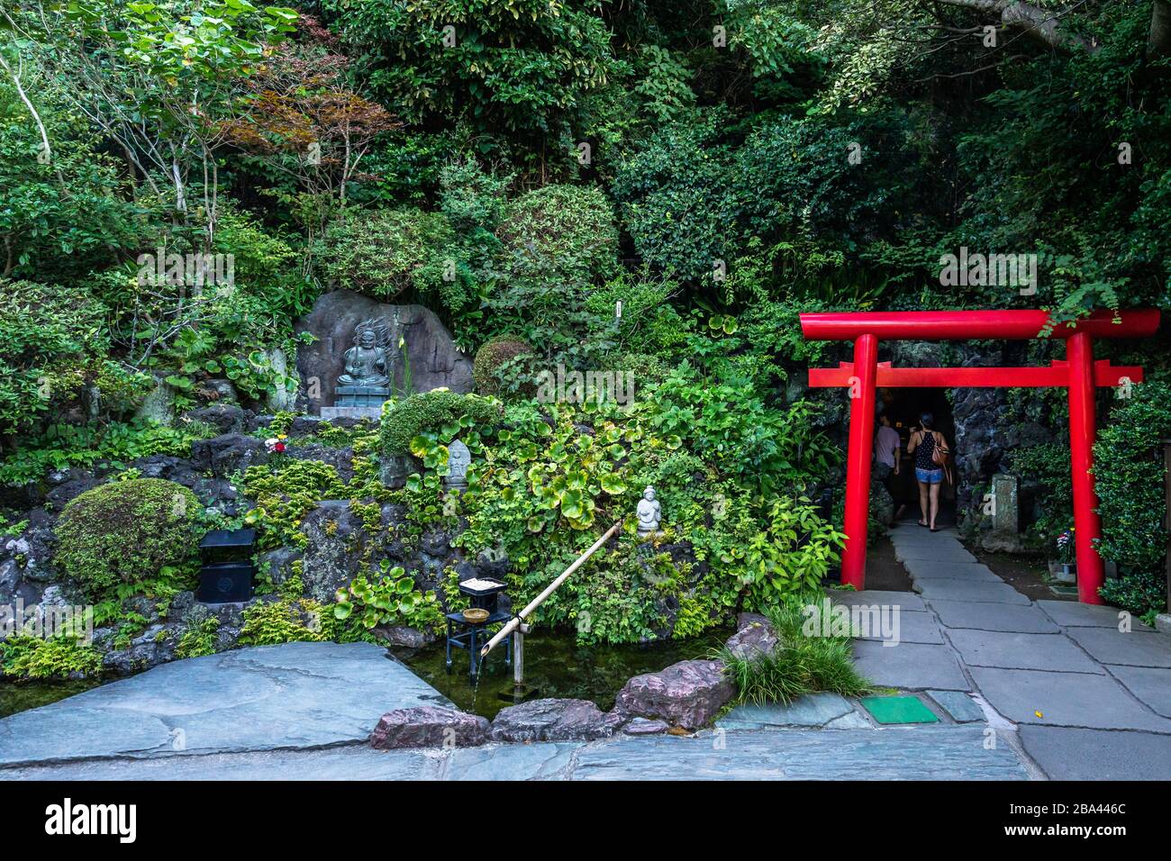 Tori gate at the entrance of a small cave next to the gardens of ...