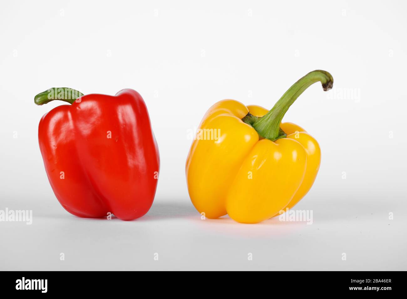 Red and yellow color peppers on white background Stock Photo - Alamy