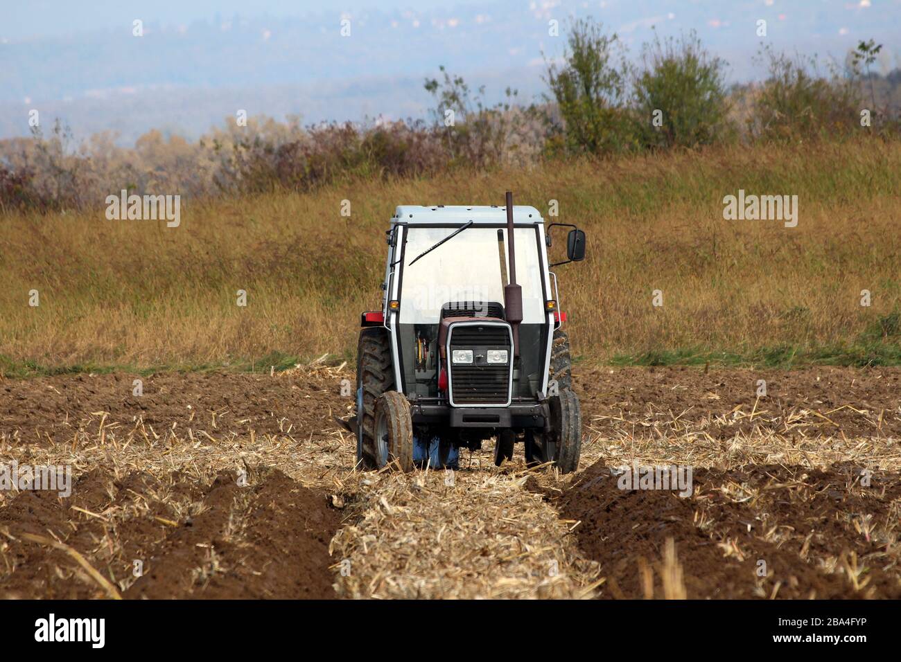 Older tractor with glass cabin left in middle of local field during ...