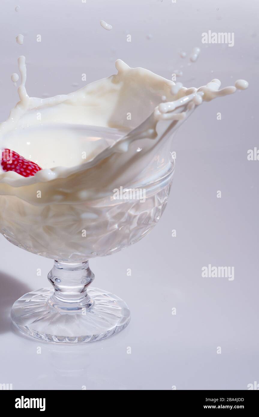 Cream splashing from cut glass dish Stock Photo - Alamy