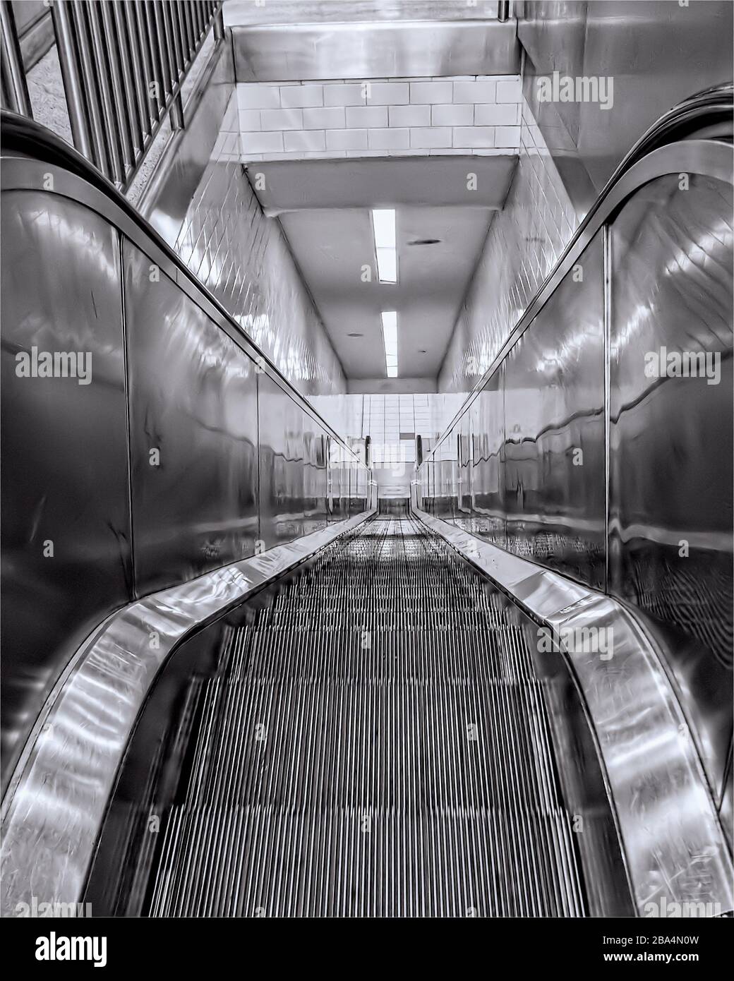 Closeup of black and white, shine metal escalator with leading lines ...