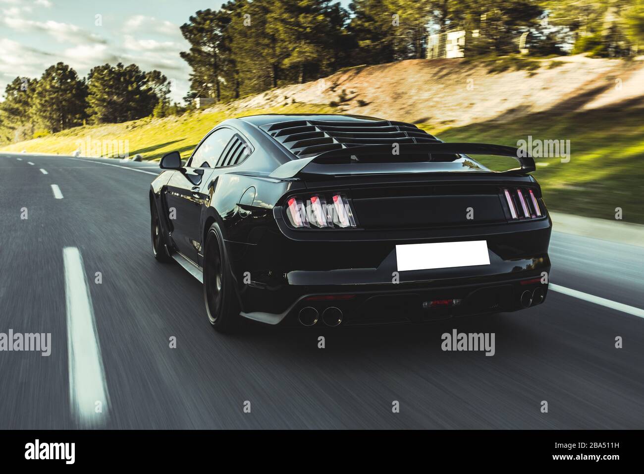 Black sport car with black vinyl windows on the road, back view Stock ...