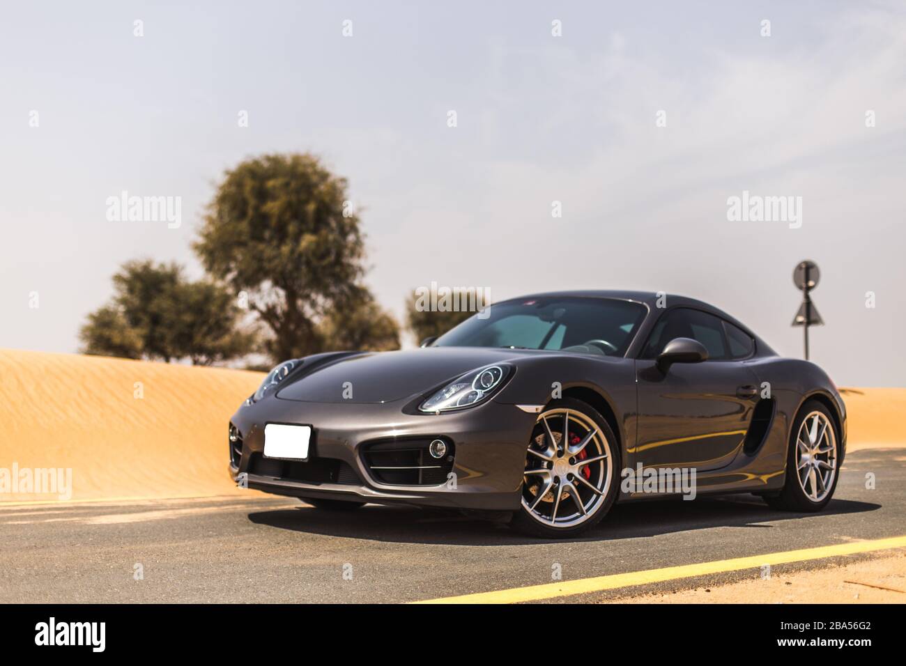 Driving a grey color sport car in the desert under the sun Stock Photo ...