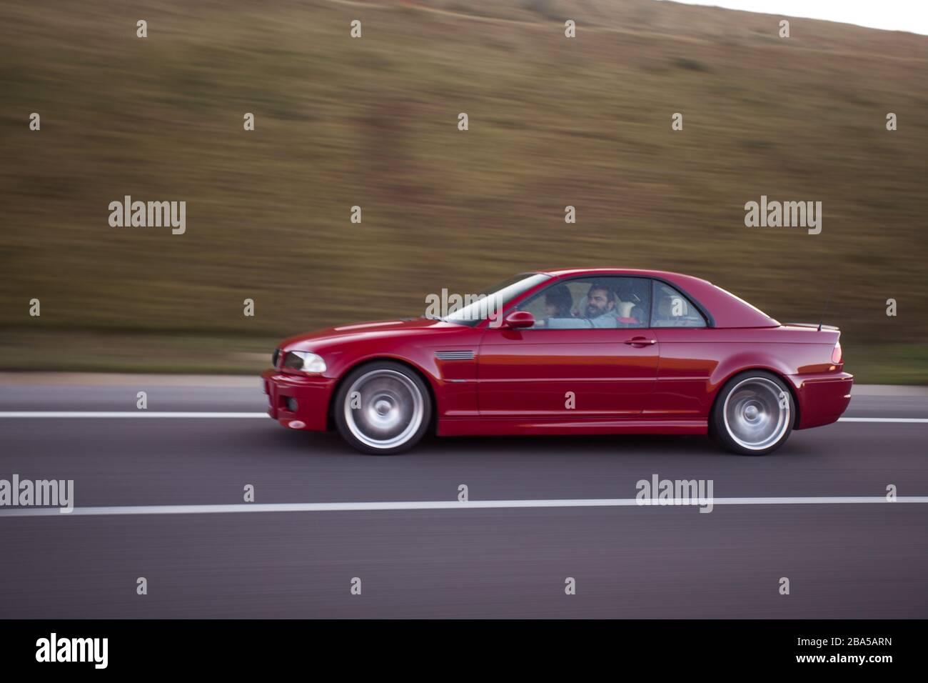Red sedan car driving on the highway across the hills Stock Photo - Alamy