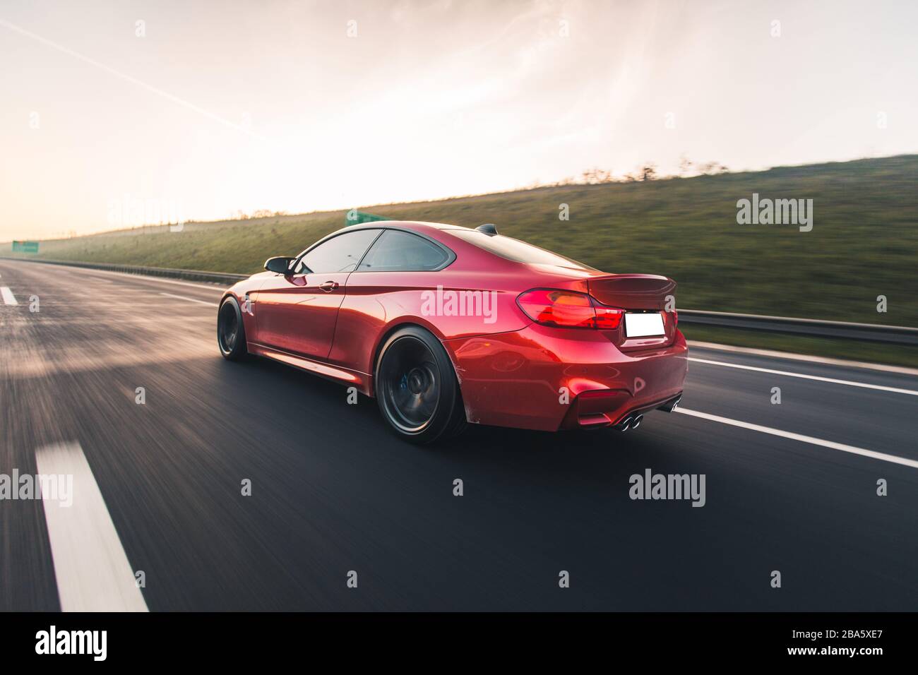 Red luxury sedan driving view from behind Stock Photo - Alamy