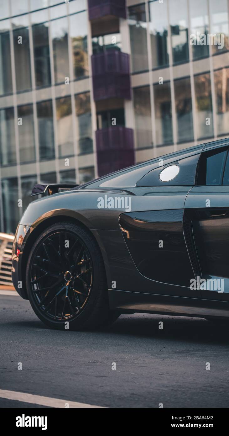 Dark grey brand model sport car in the street, back wheels and bumper ...