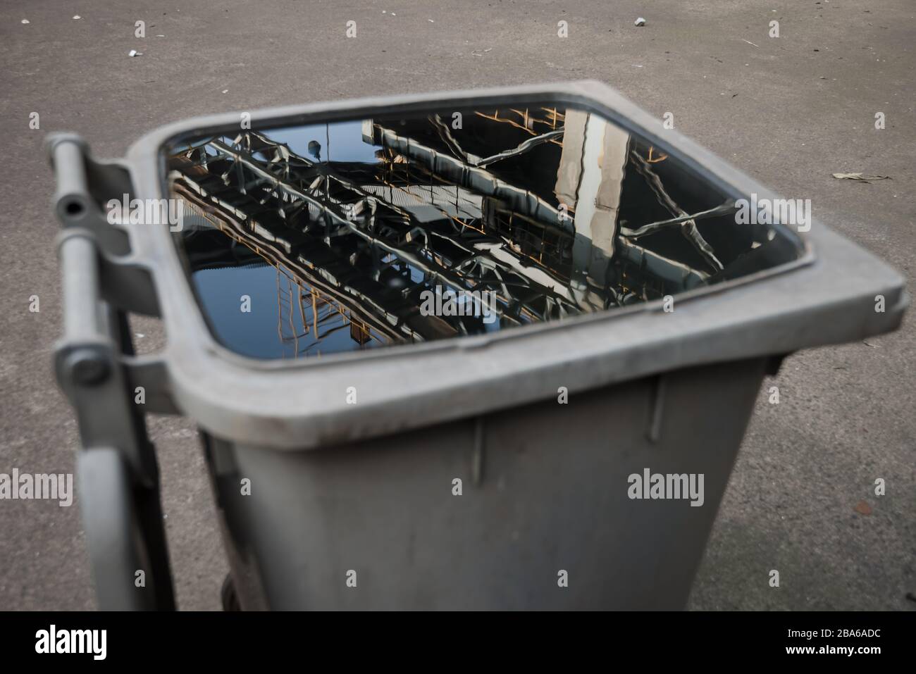 an abandoned garbage bin full of rainwater in an abandoned factory ...